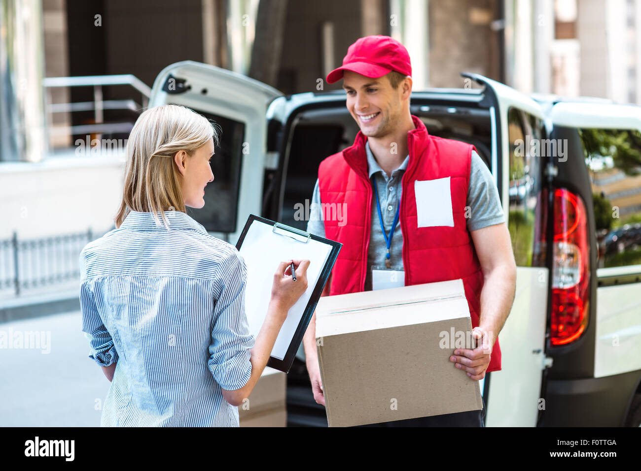 Courier Delivering Package By Van Stock Photo - Alamy