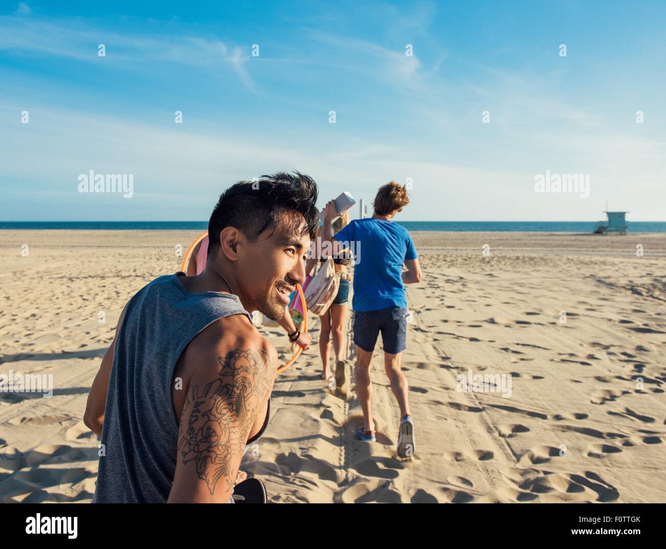 Group of friends walking on beach, rear view Stock Photo - Alamy
