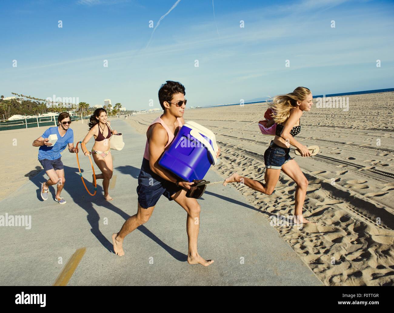 Group of friends, running towards beach Stock Photo - Alamy