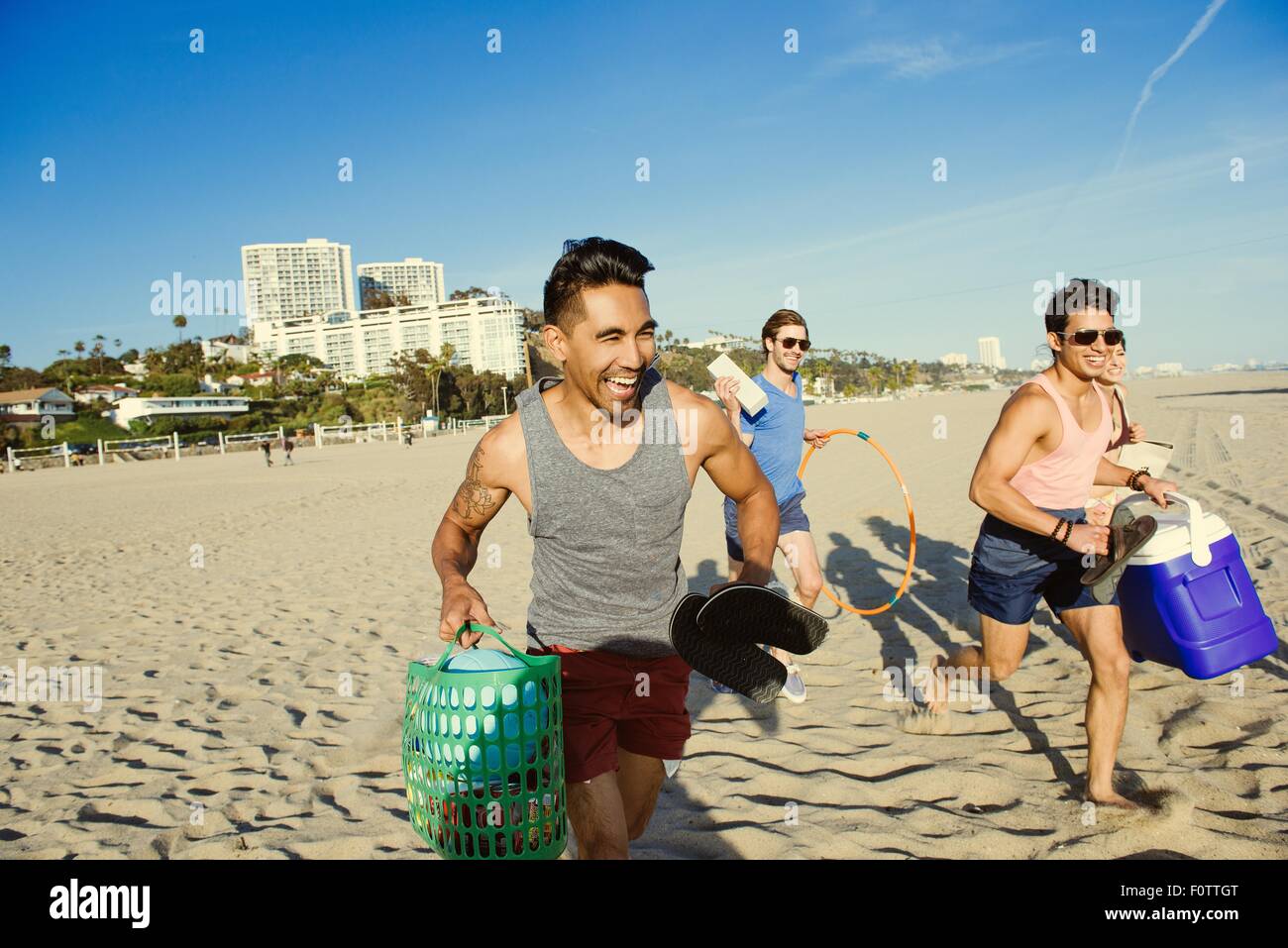 Group of friends, running towards beach Stock Photo - Alamy