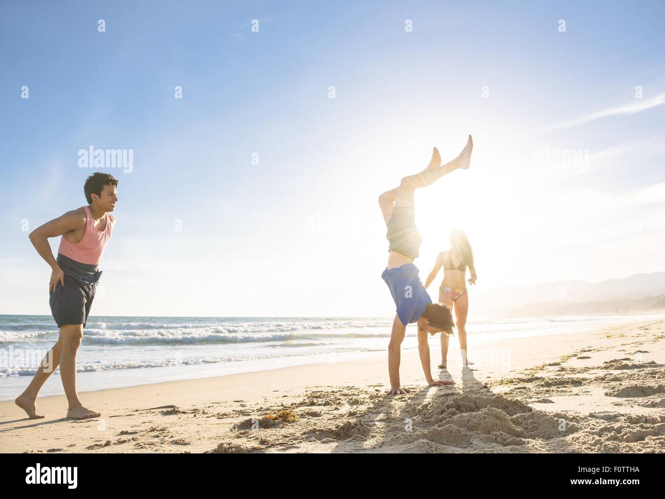 Group of friends fooling around on beach Stock Photo - Alamy
