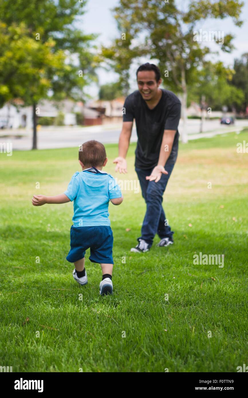 Young man playing with toddler brother in park Stock Photo - Alamy