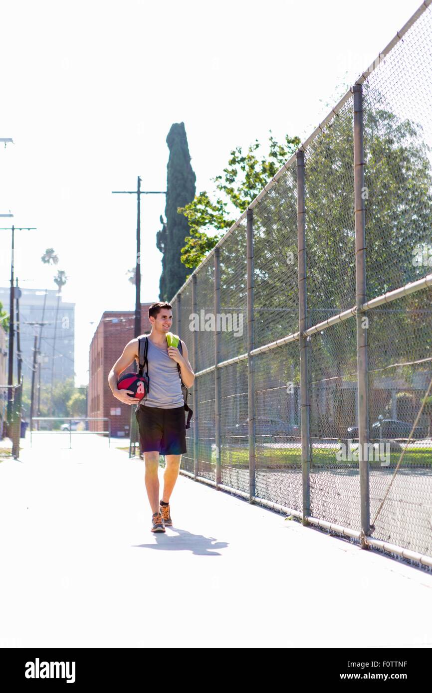 Young male basketball player walking to basketball practice Stock Photo ...