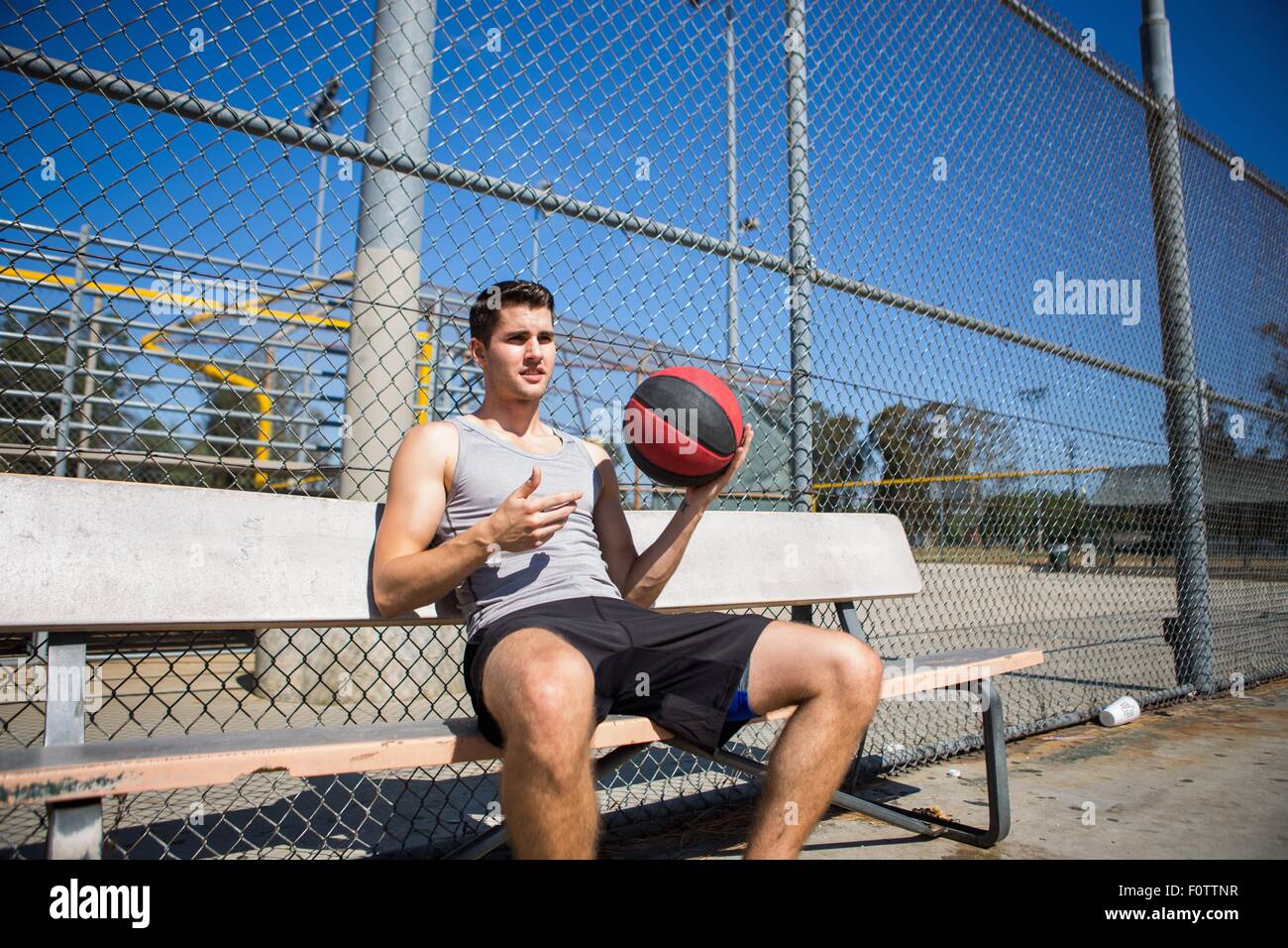 Young male basketball player taking a break on bench Stock Photo - Alamy