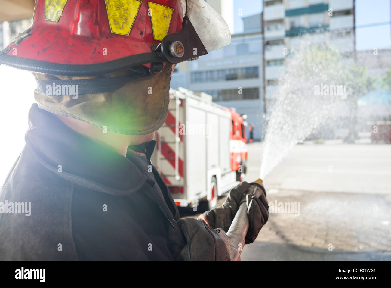 Firefighter Spraying Water While Practicing At Fire Station Stock Photo ...