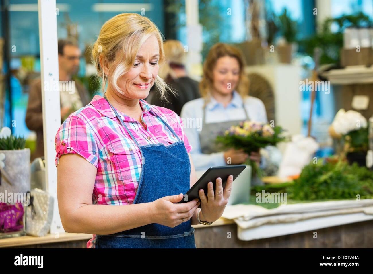 Smiling Female Florist Using Digital Tablet In Flower Shop Stock Photo ...