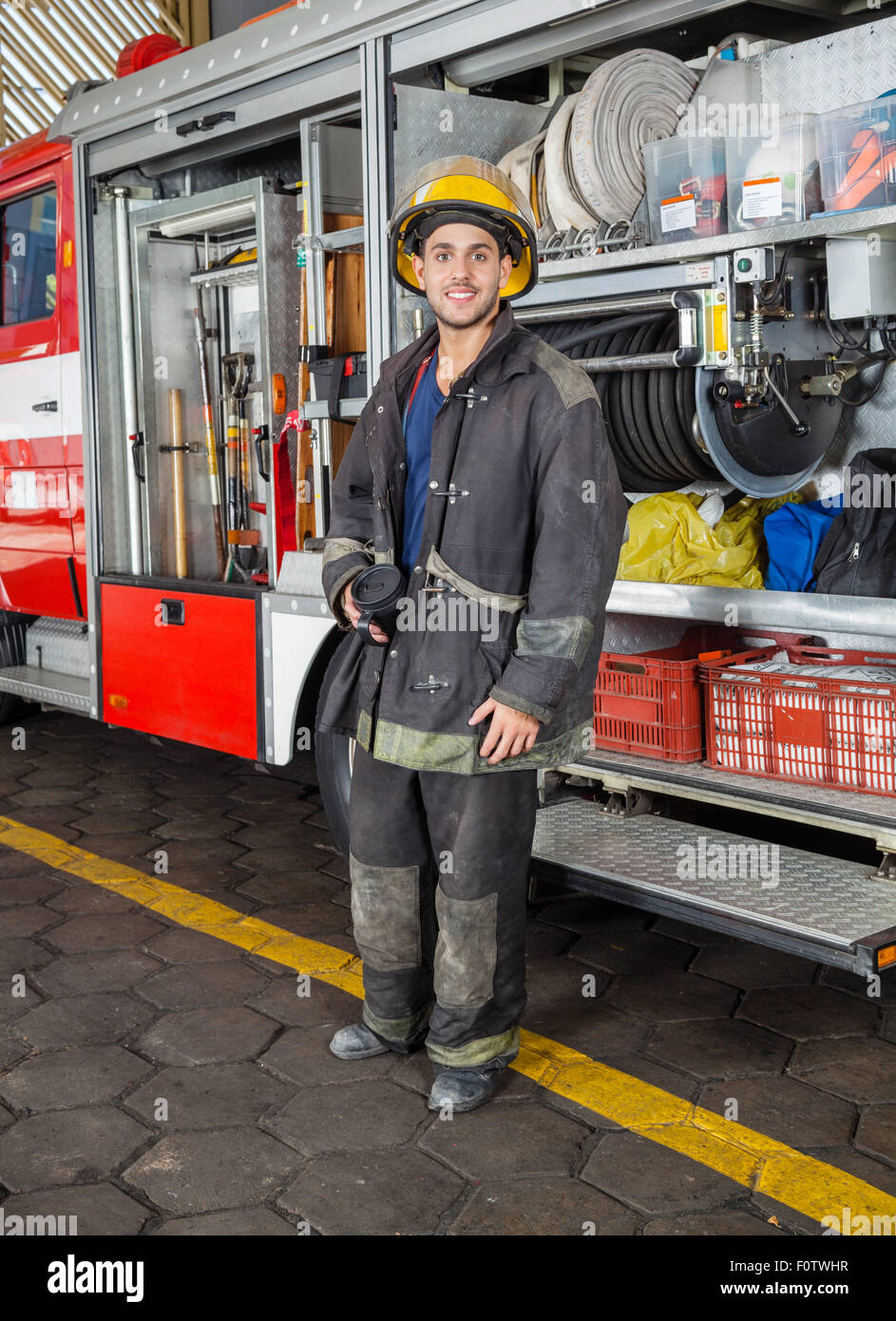Confident Fireman Standing By Truck At Fire Station Stock Photo - Alamy