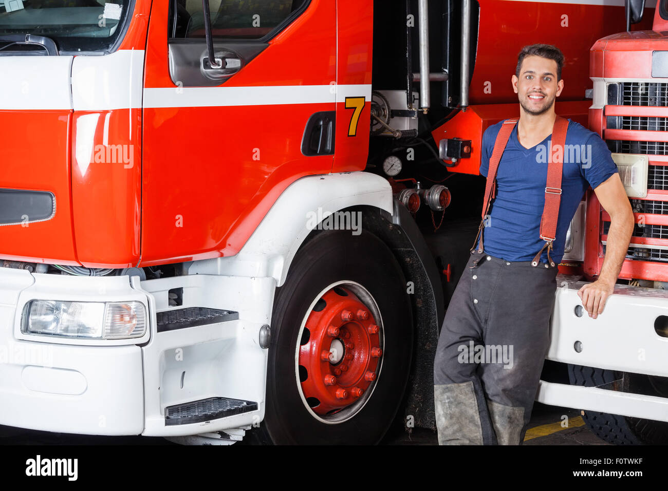 Confident Firefighter Leaning On Truck Stock Photo - Alamy