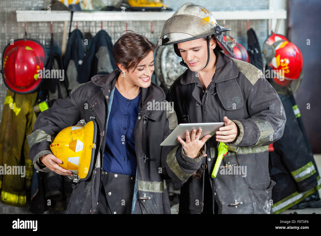 Firefighters Using Digital Tablet At Fire Station Stock Photo - Alamy