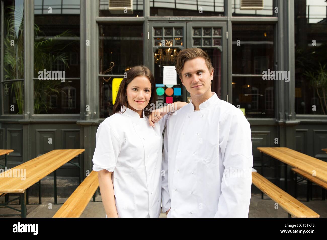 Couple in chef uniforms standing outside of work Stock Photo - Alamy