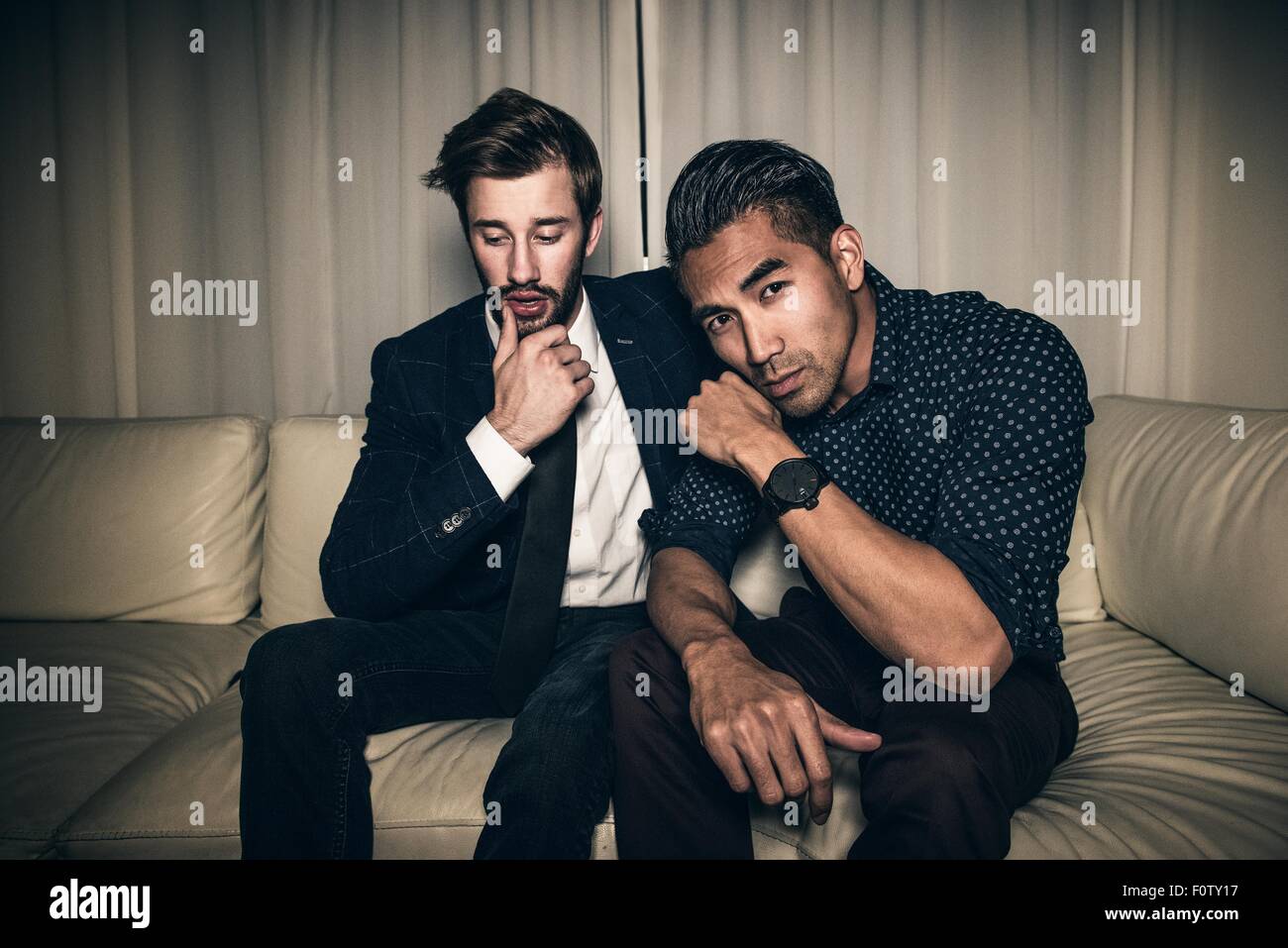 Two young men sitting on sofa Stock Photo - Alamy Two young men sitting on sofa Stock Photo - Alamy