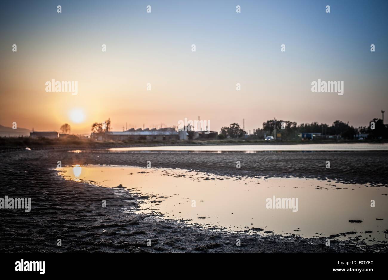 Sun reflecting in pool of water, sunset, Cagliari, Sardinia, Italy ...