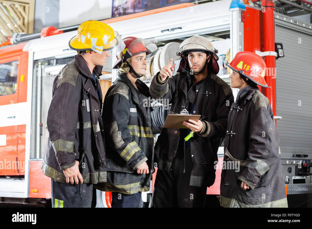 Firefighter Showing Something To Colleagues At Fire Station Stock Photo ...