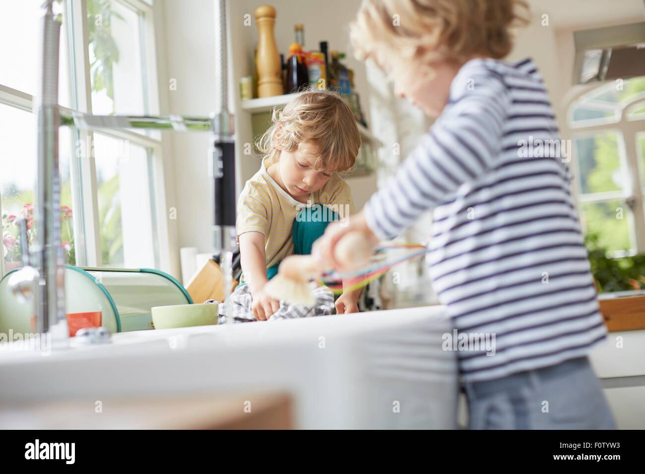 Two young brothers doing washing up Stock Photo - Alamy