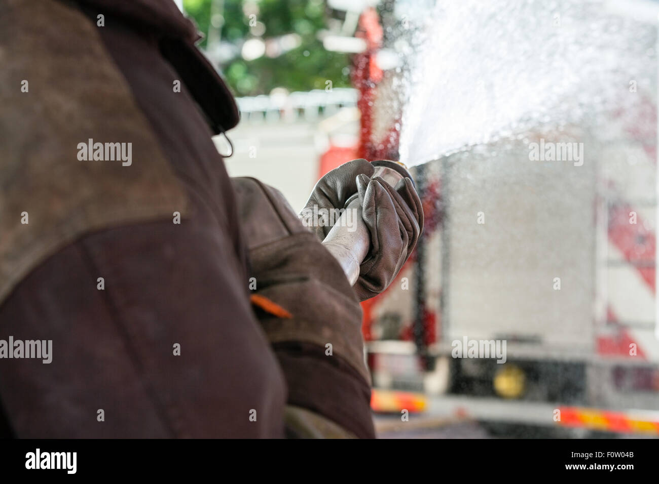 Fireman Spraying Water During Practice Stock Photo - Alamy