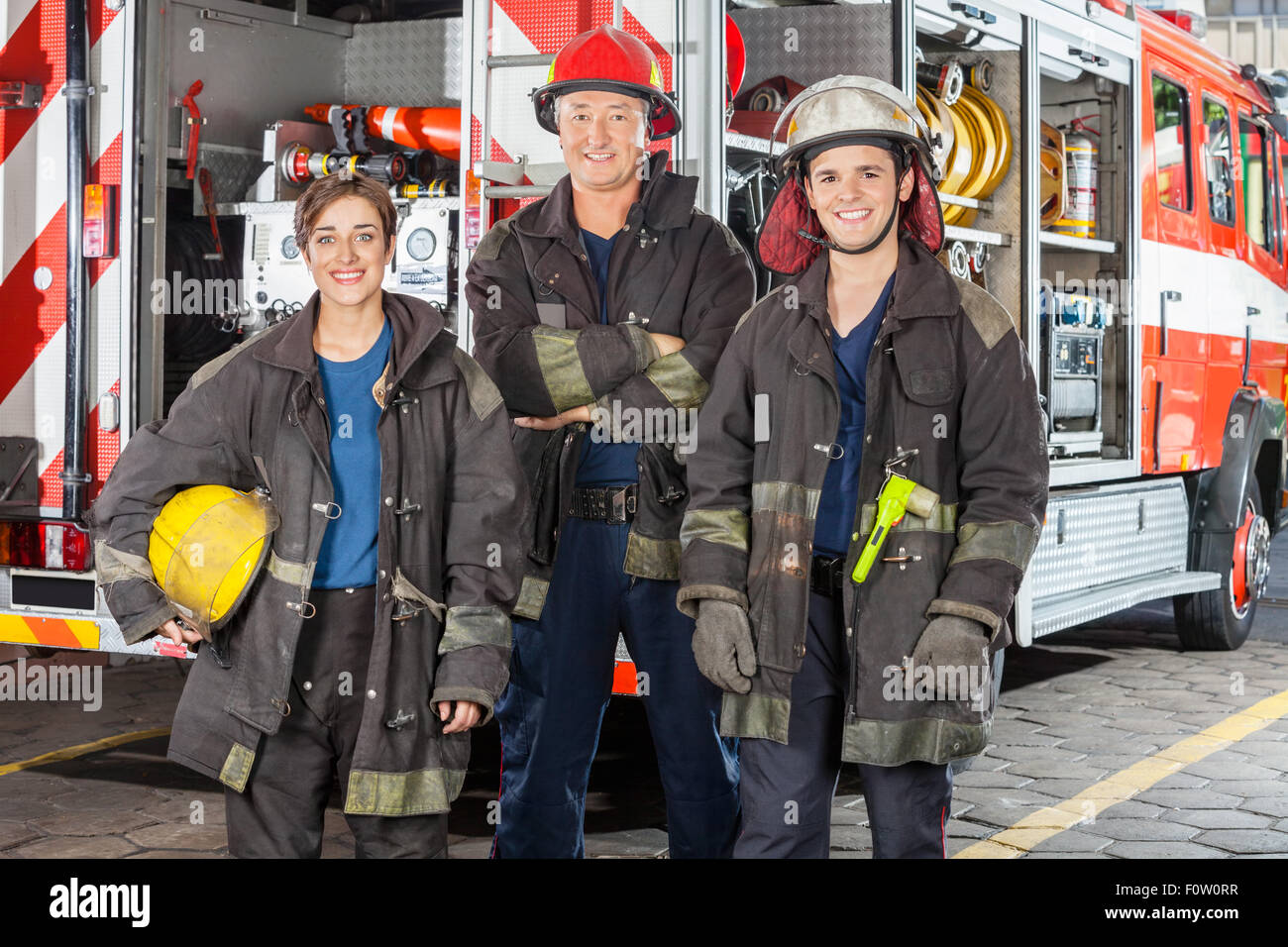 Happy Firefighters Standing Against Truck Stock Photo - Alamy
