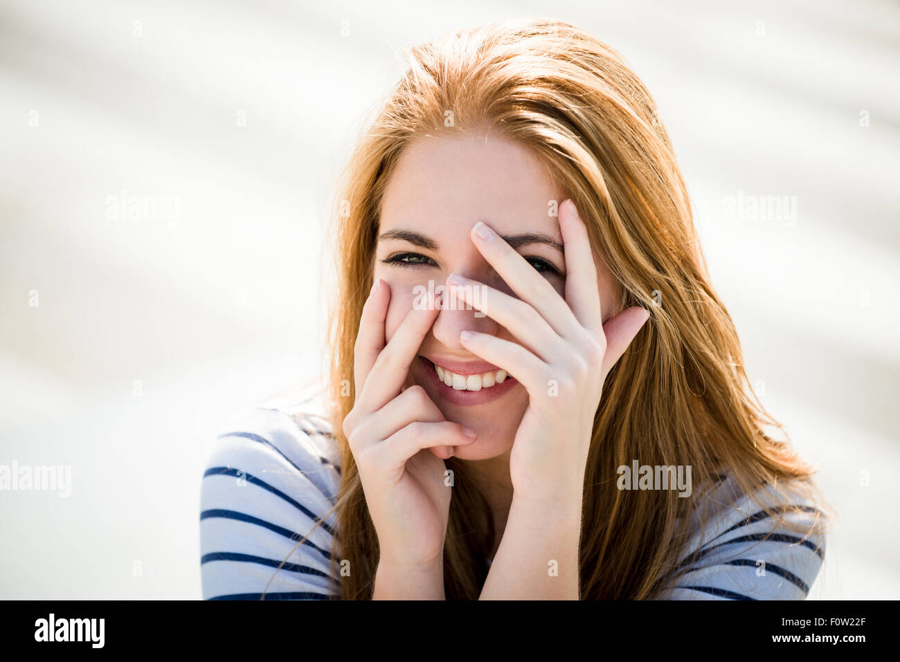 Teenager portrait - smiling girl outdoor with hands before face Stock ...