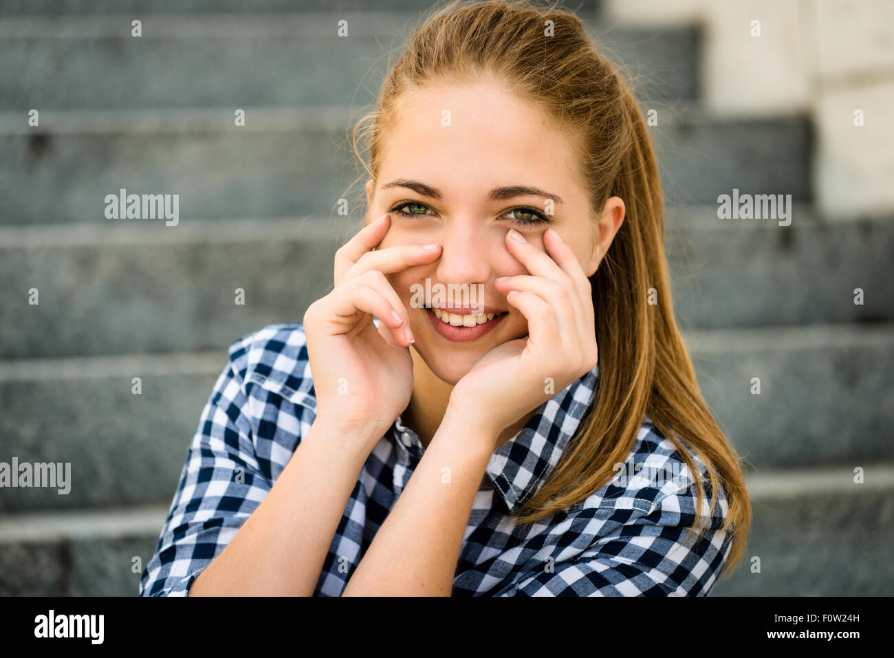Teenager portrait - smiling girl outdoor with hands before face Stock ...