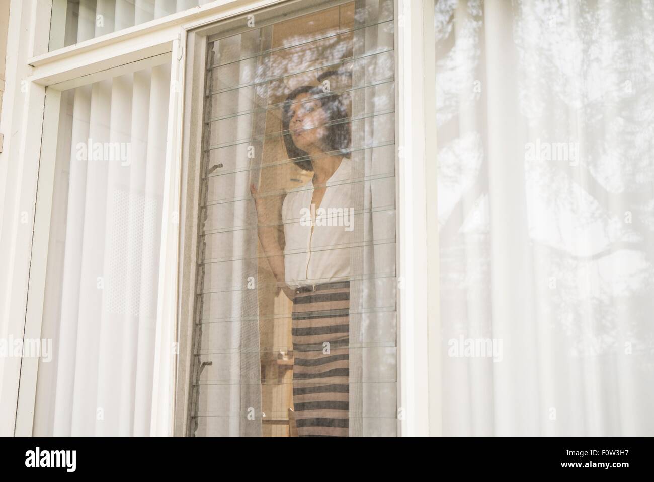 Women peering out the window hi-res stock photography and images - Alamy