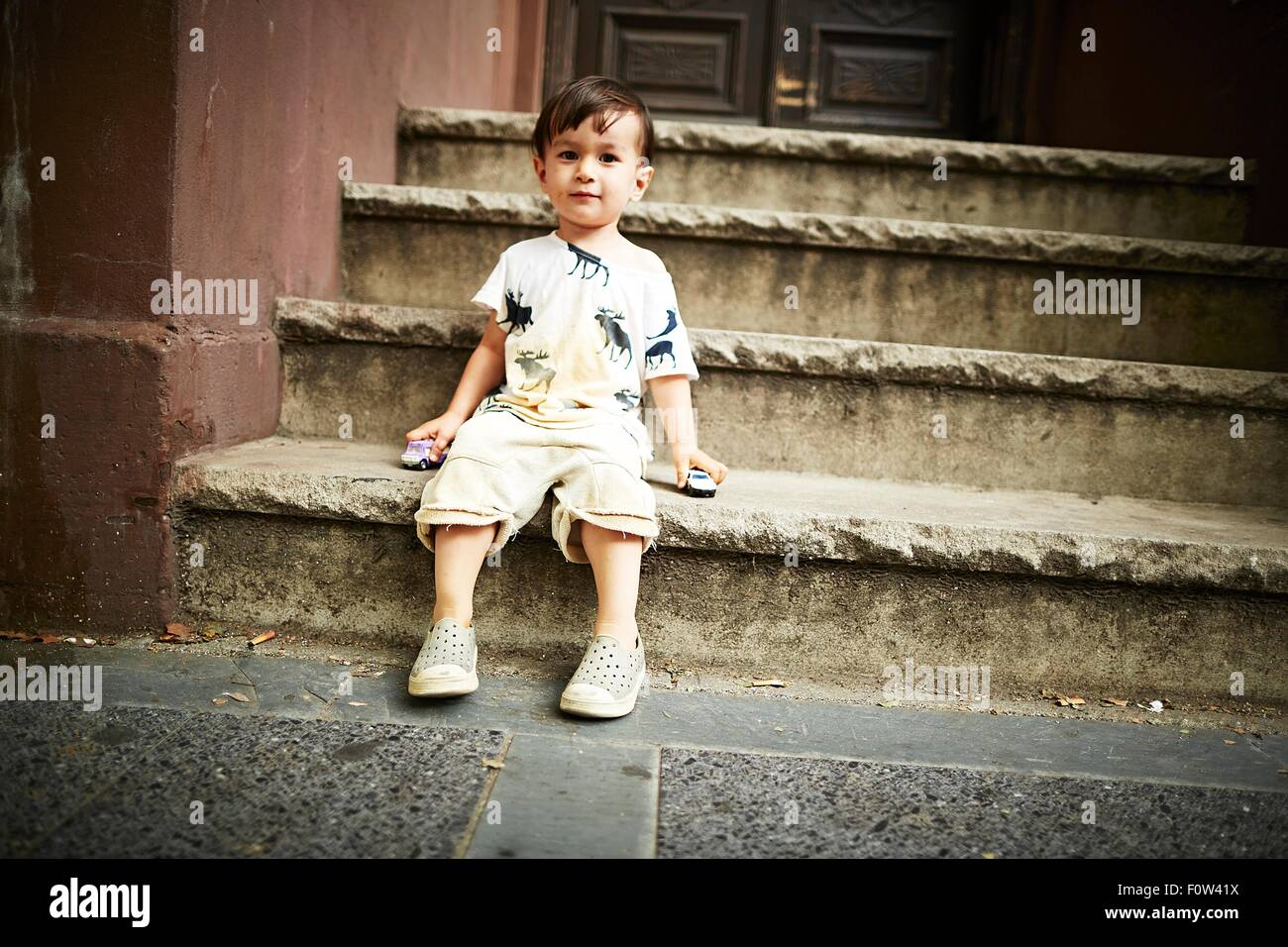 Boy sitting on steps Stock Photo - Alamy