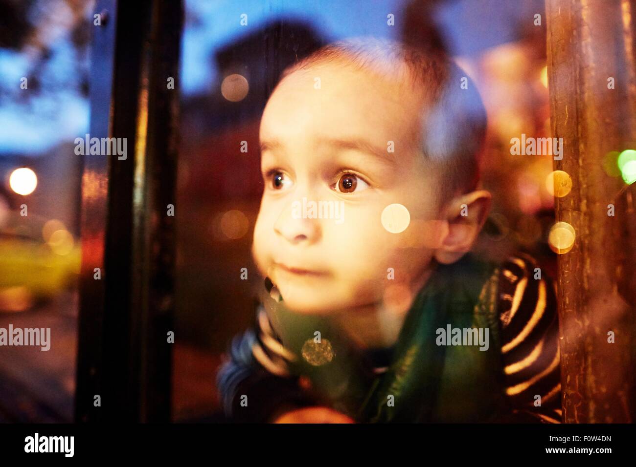 Boy looking through window Stock Photo - Alamy