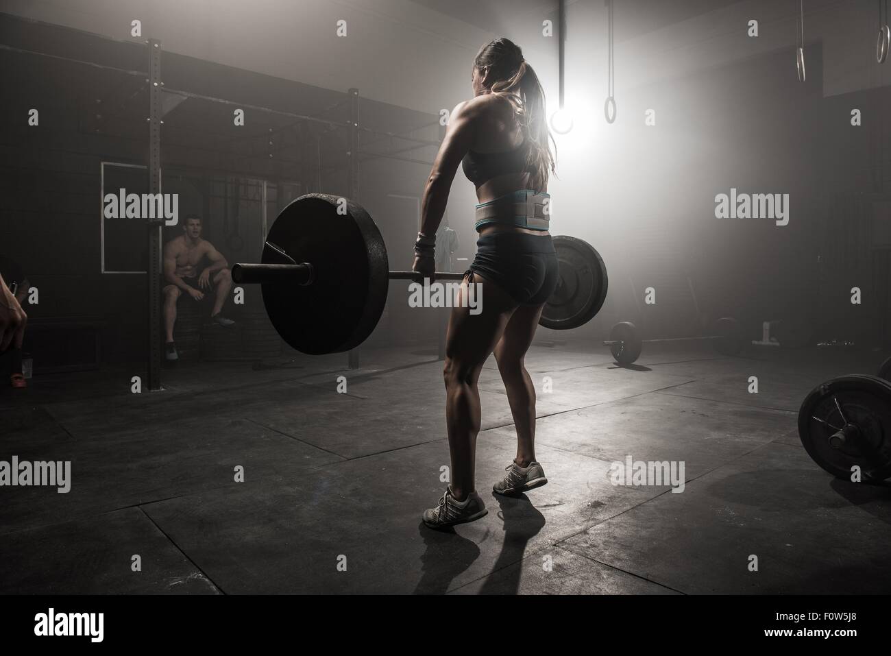 Young woman lifting barbell, rear view Stock Photo - Alamy