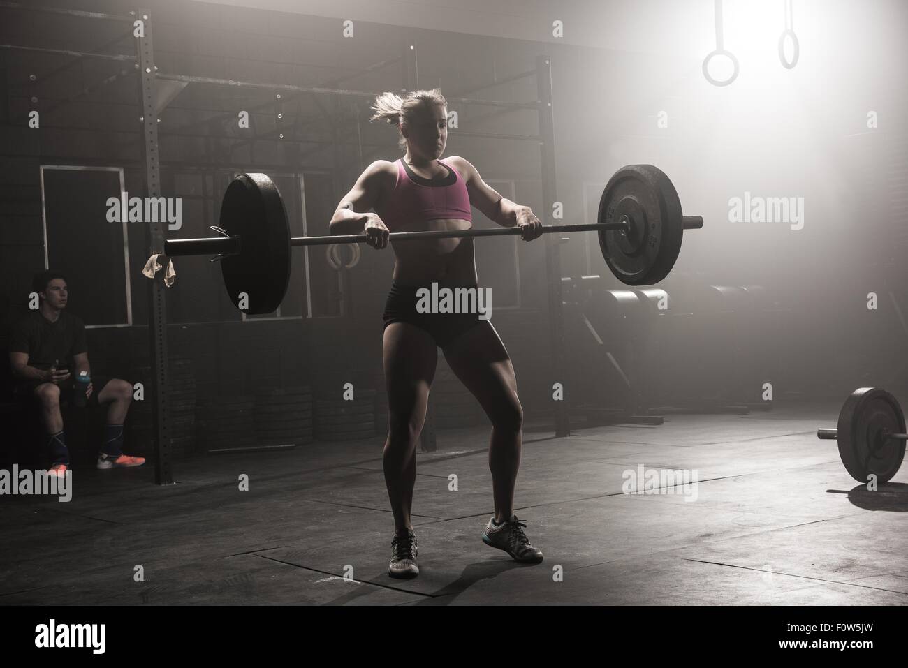 Young woman lifting barbell Stock Photo - Alamy
