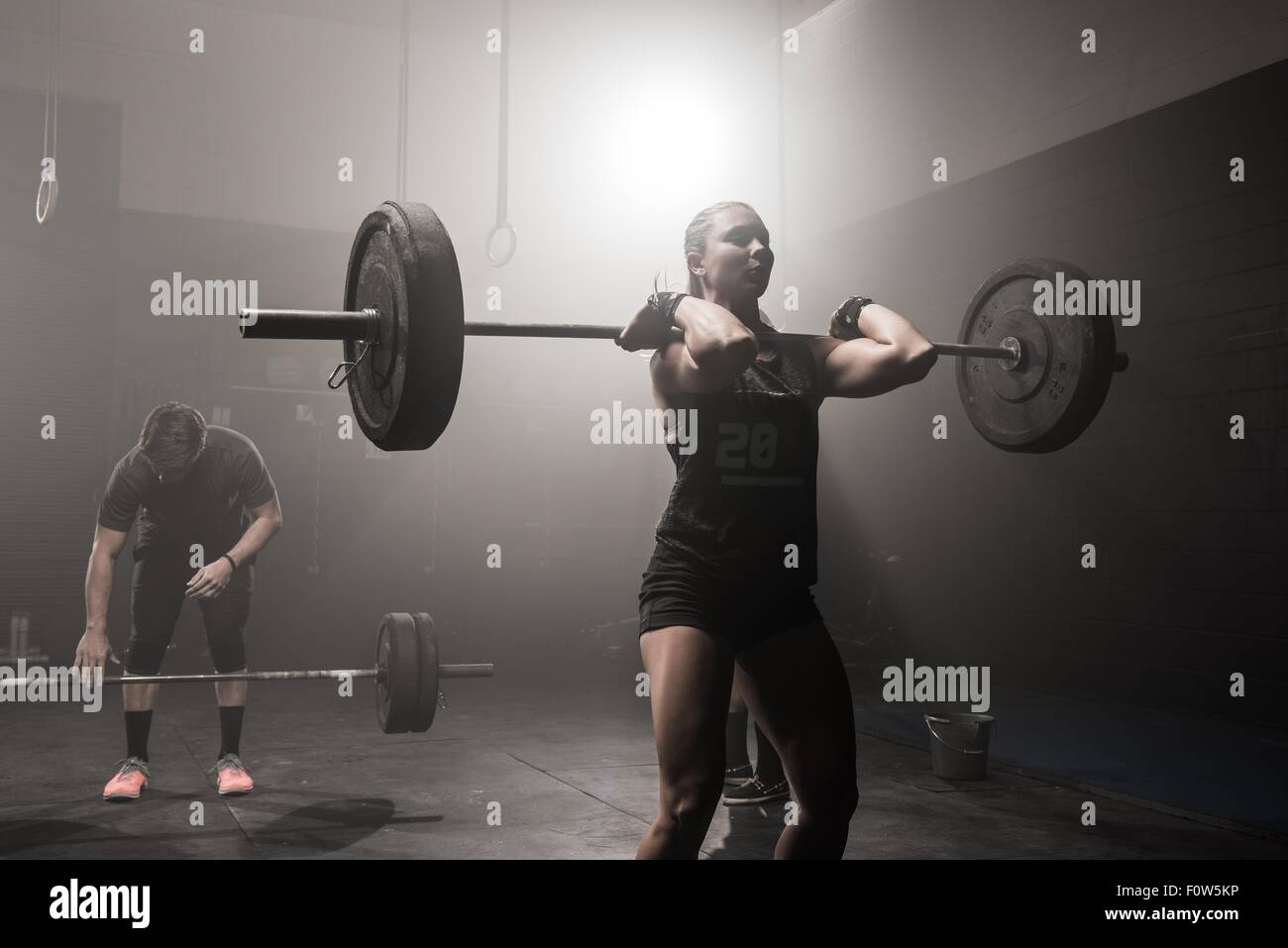 Young woman lifting barbell Stock Photo - Alamy