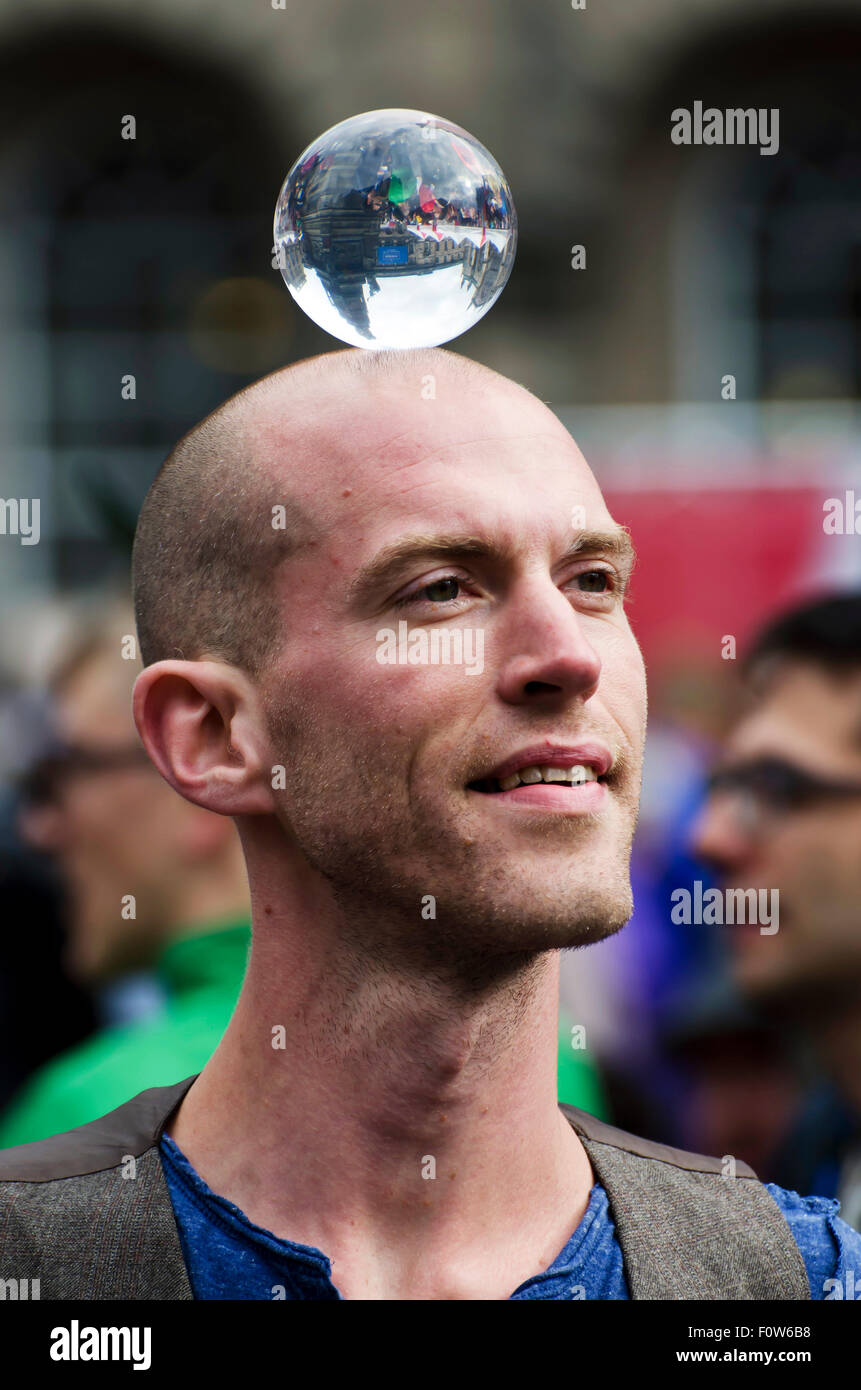Performer balancing a glass ball on his head at the Edinburgh Festival ...