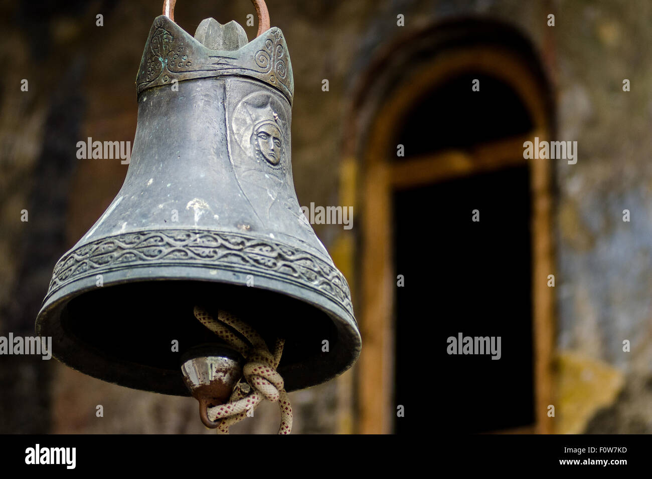 Bell hanging near an ancient doorway in a historic building at dusk ...