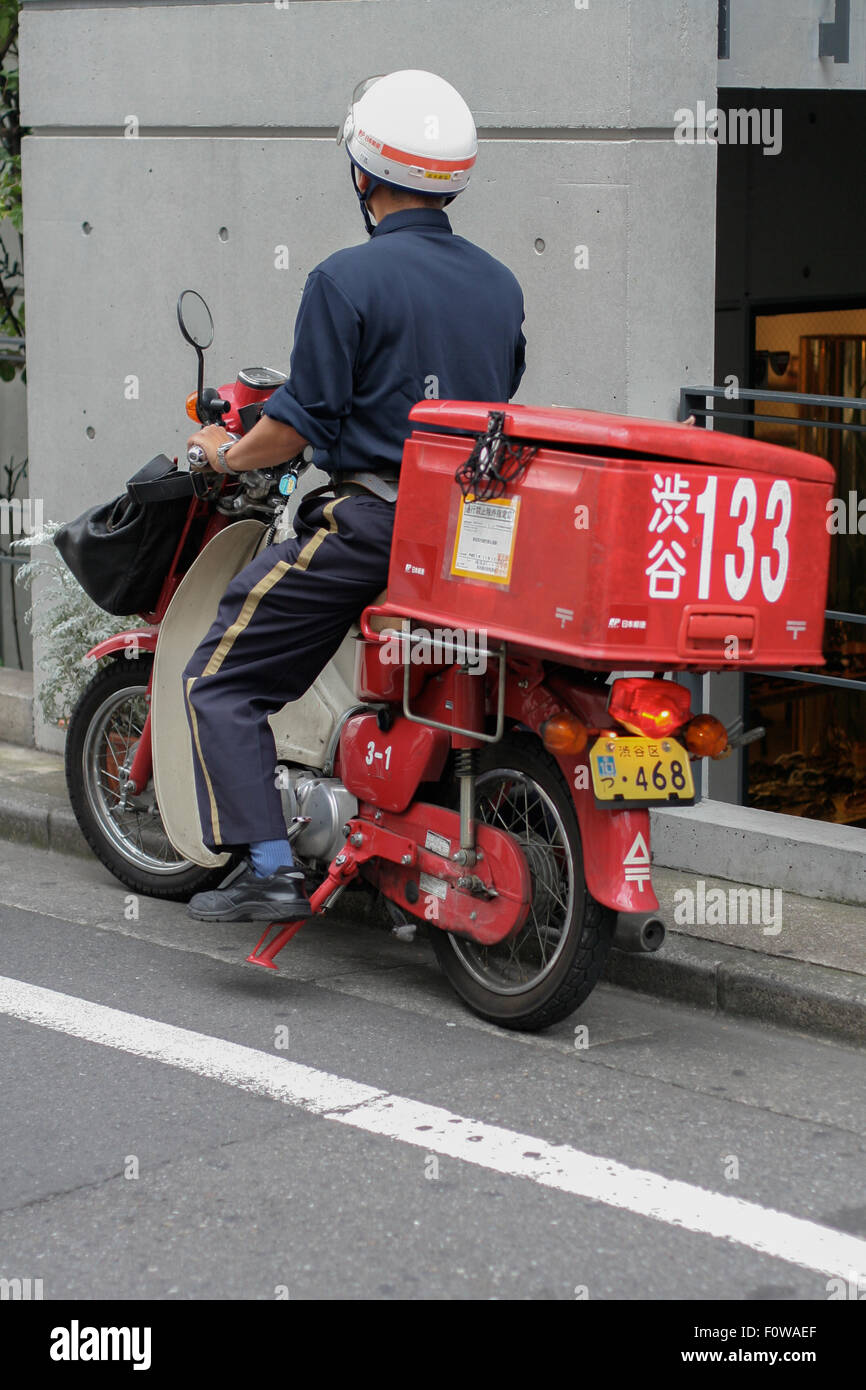 Post office delivery guy on red scooter Stock Photo - Alamy