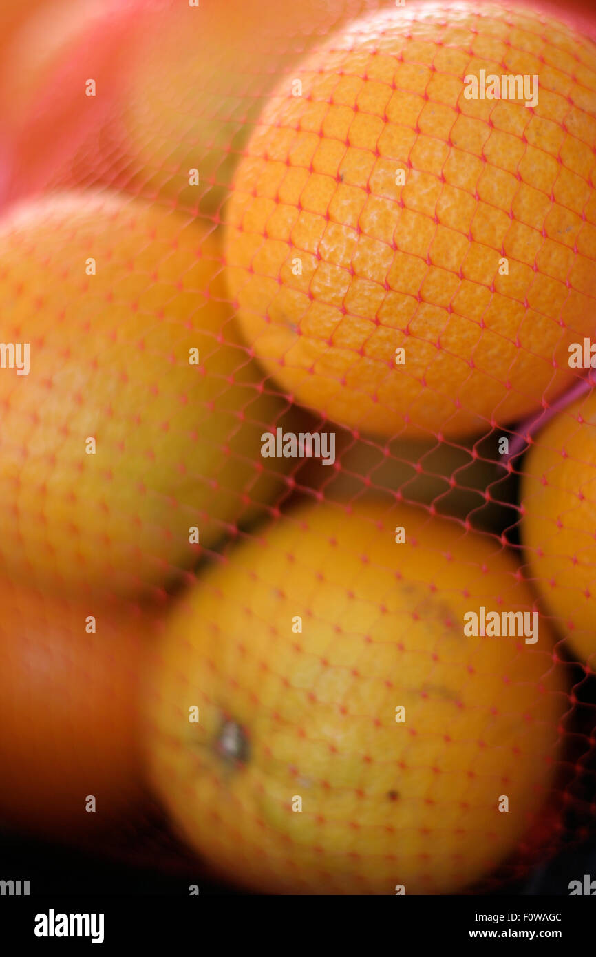 Oranges in a red net depth of field Stock Photo - Alamy