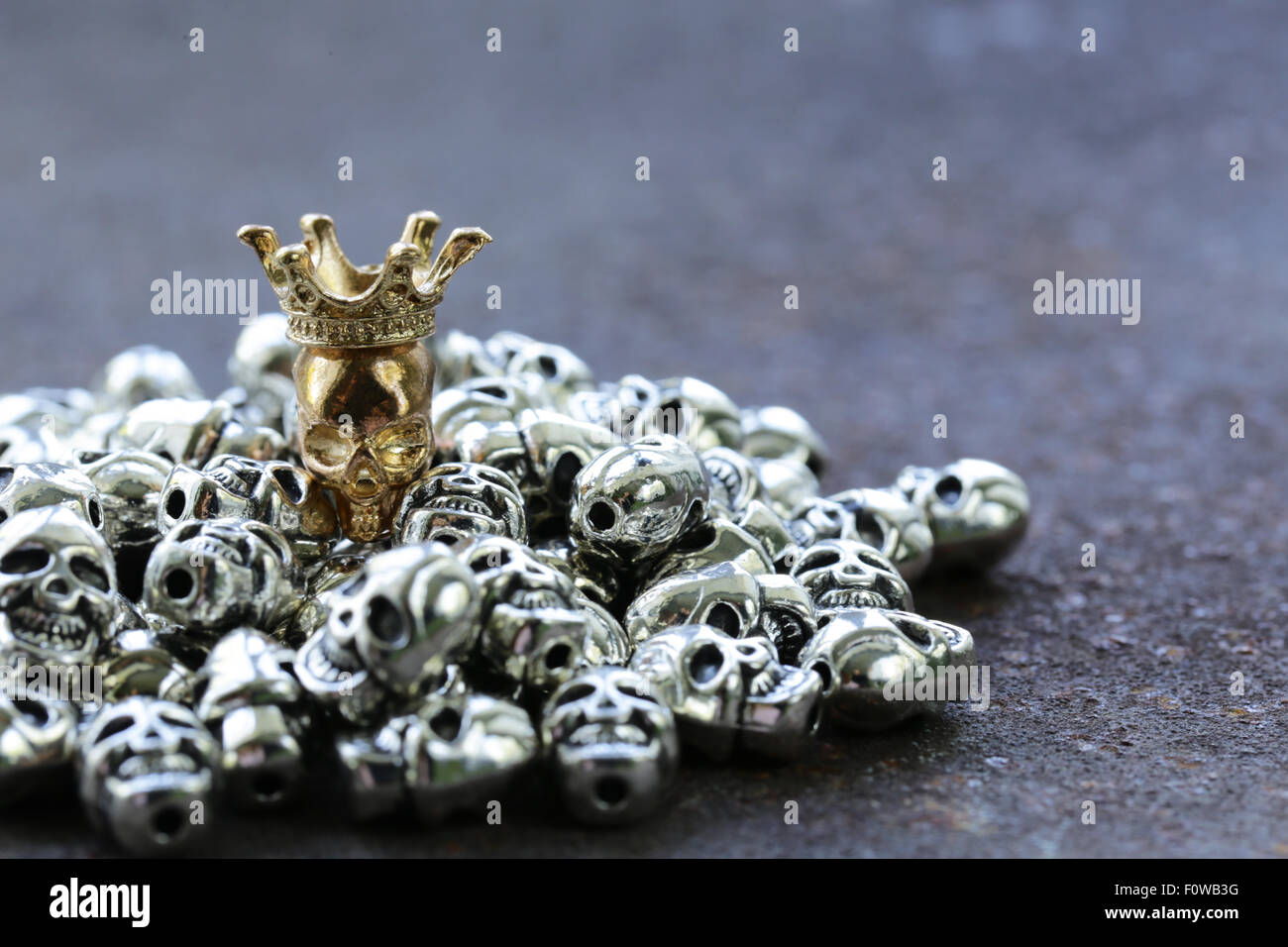 Gold unique skull among ordinary metal skulls Stock Photo - Alamy