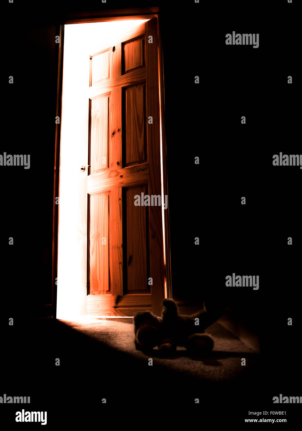 Teddy in light falling from open door Stock Photo - Alamy