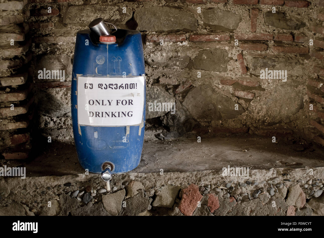 Container marked for drinking water usage in a rustic setting with ...