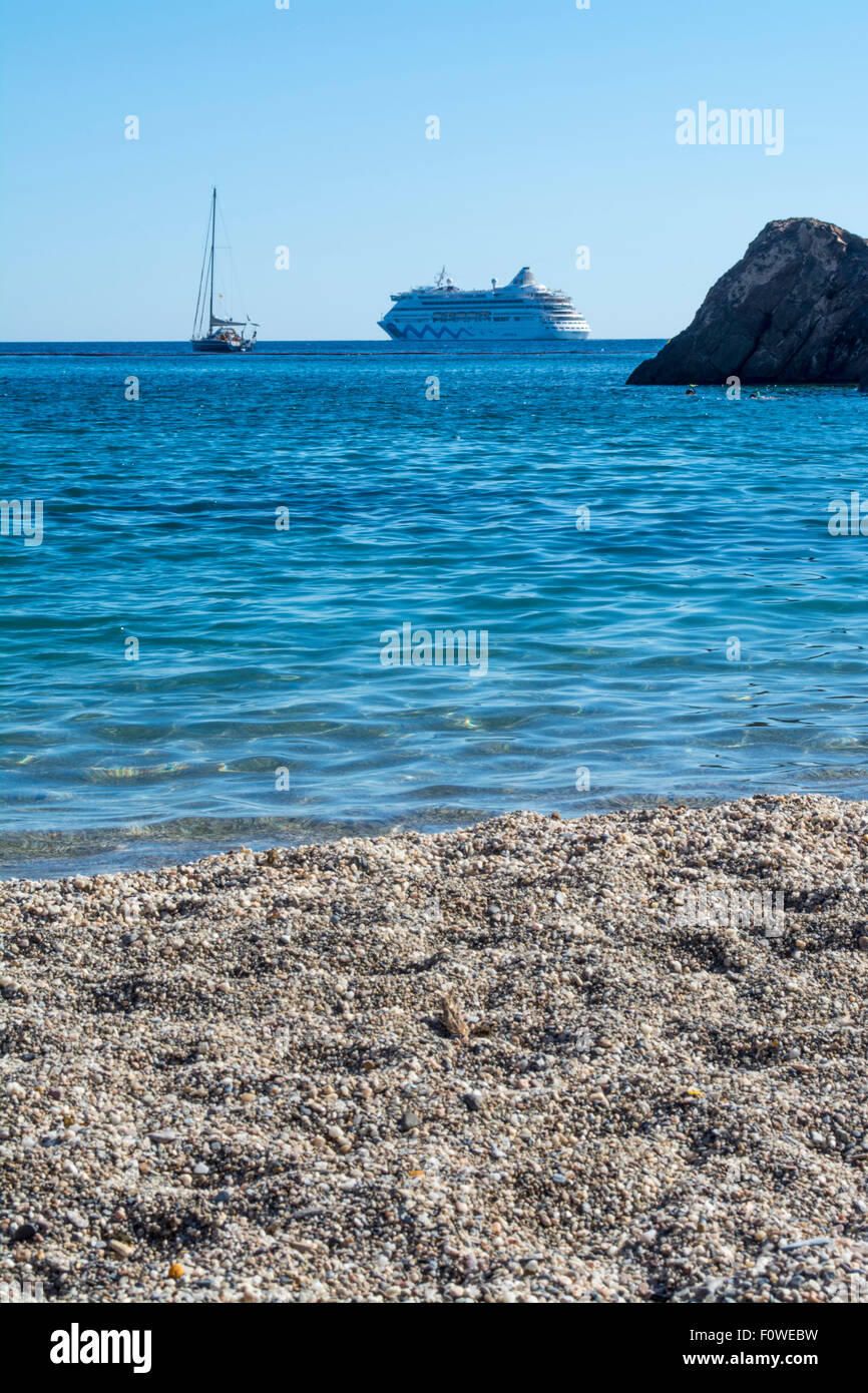 Sail boat and Ocean Liner sail past the bay at Cala Cortina, Murcia ...