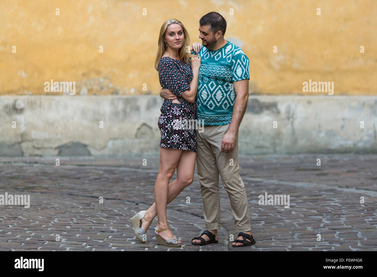 Happy young couple in love hugging against the wall of the old house ...