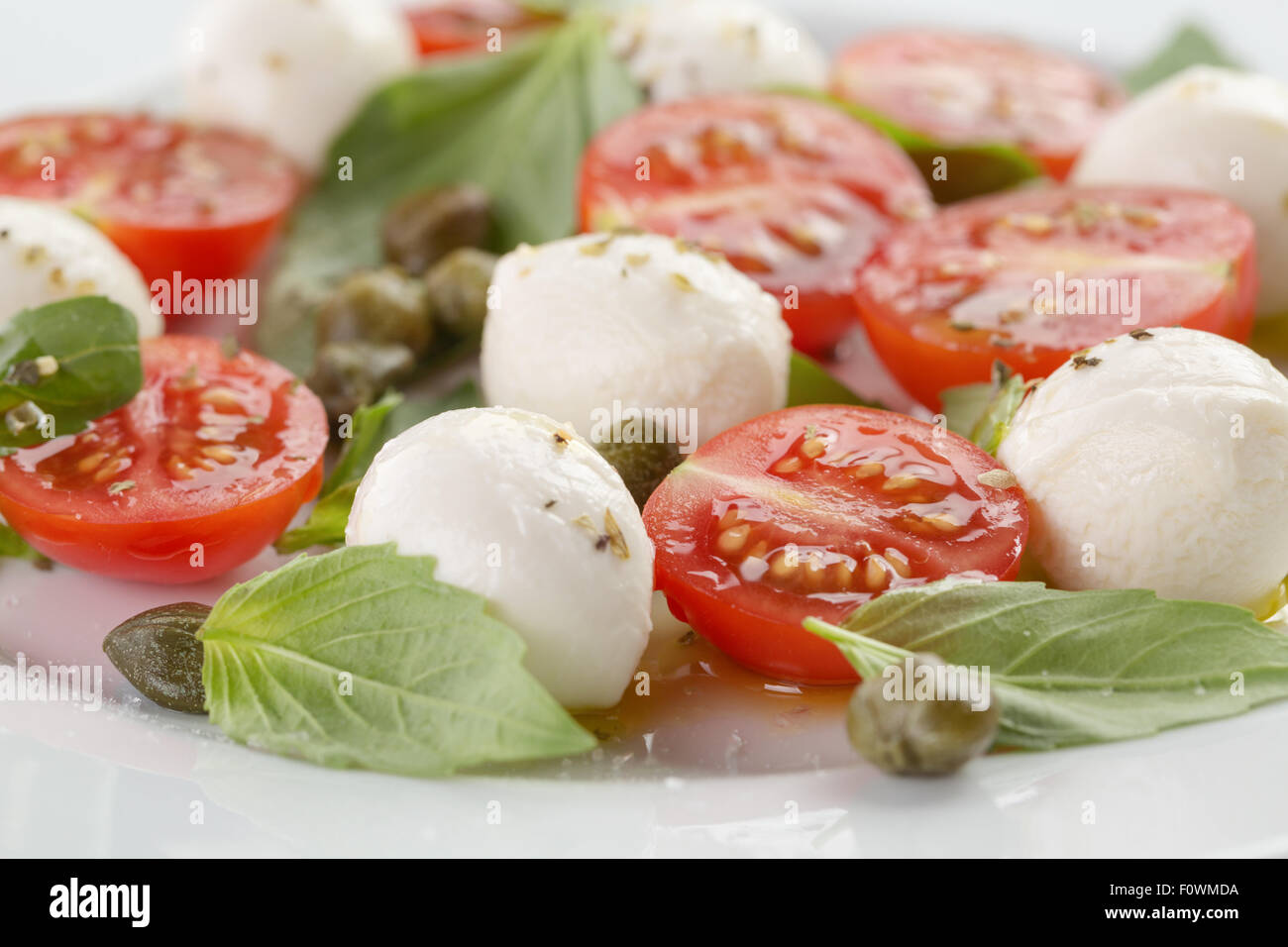 caprese salad with mini mozzarella balls, tomatoes and capers Stock ...
