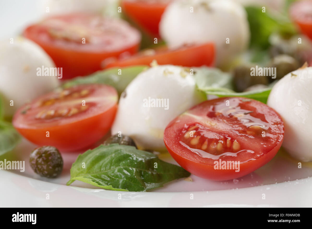 caprese salad with mini mozzarella balls, tomatoes and capers Stock ...