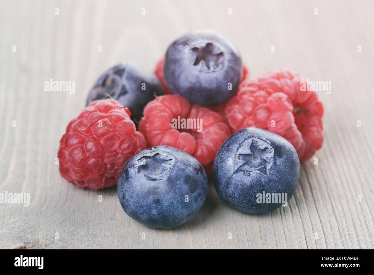 raspberries and blueberries on wood table Stock Photo - Alamy