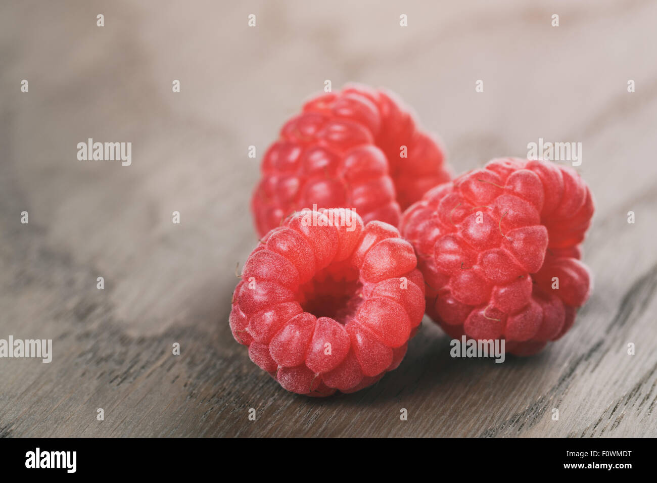 raspberries on oak wood table Stock Photo - Alamy