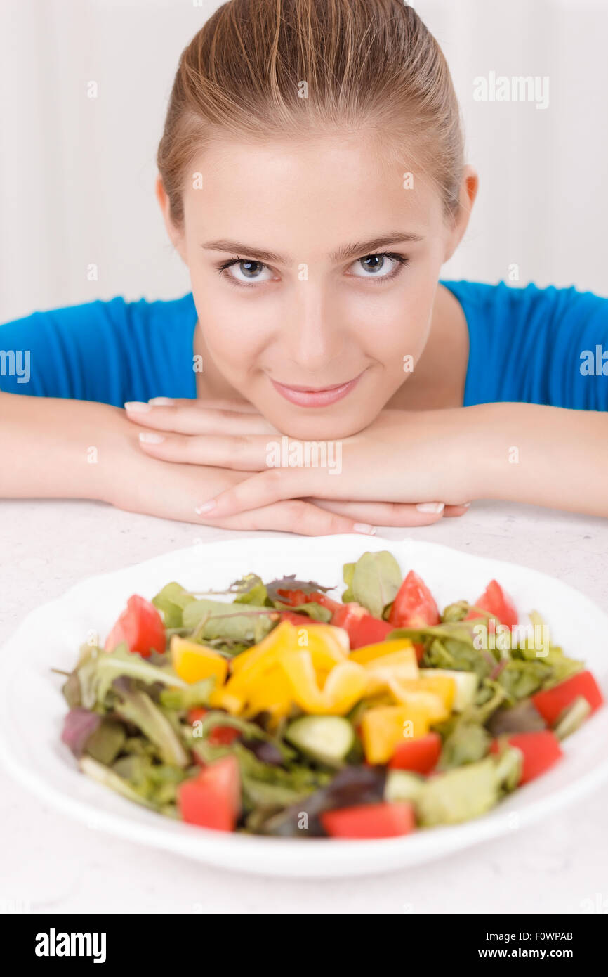 Smiling girl eating salad Stock Photo - Alamy
