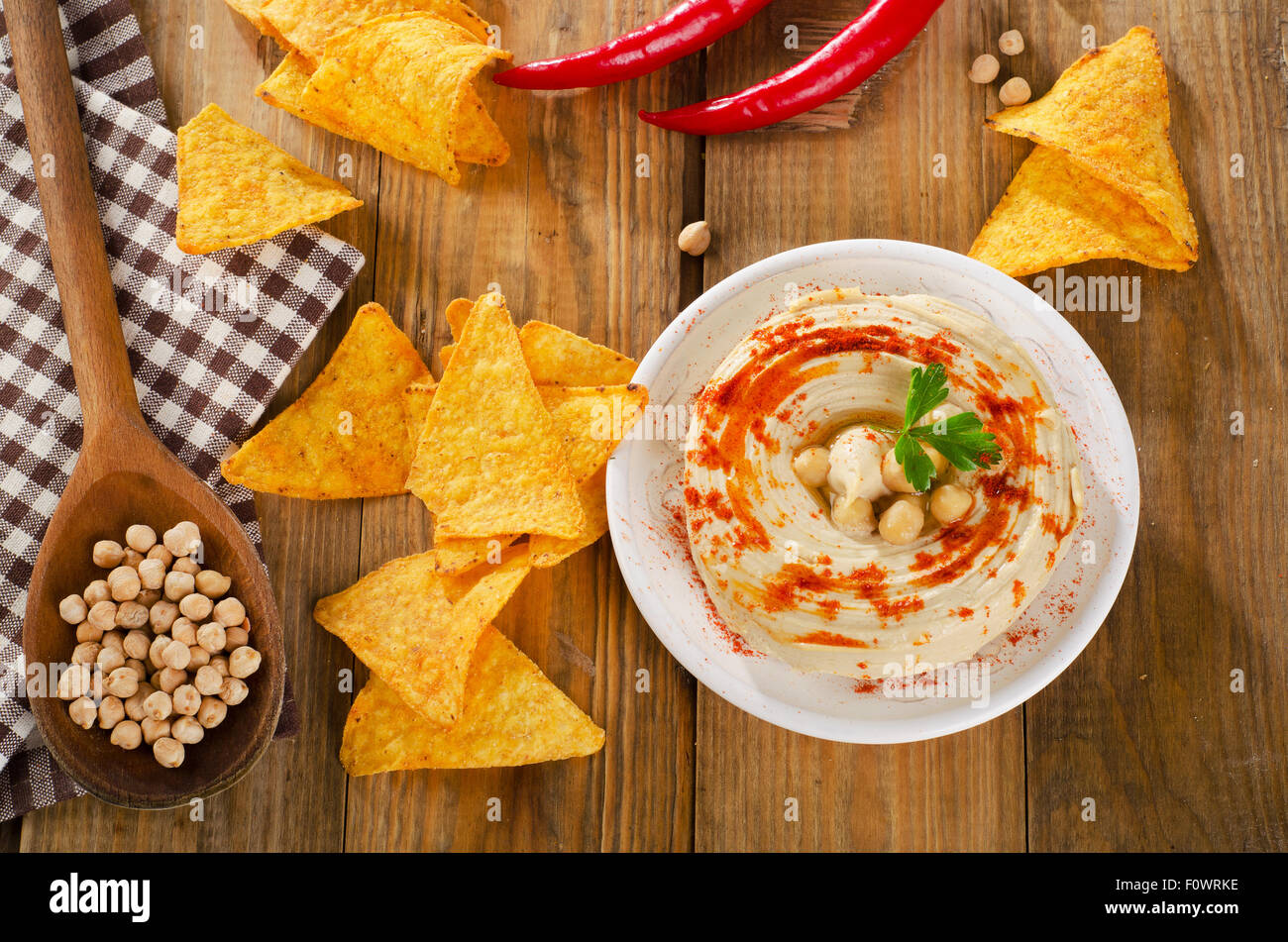 Hummus with nachos on a rustic wooden table. Top view Stock Photo - Alamy