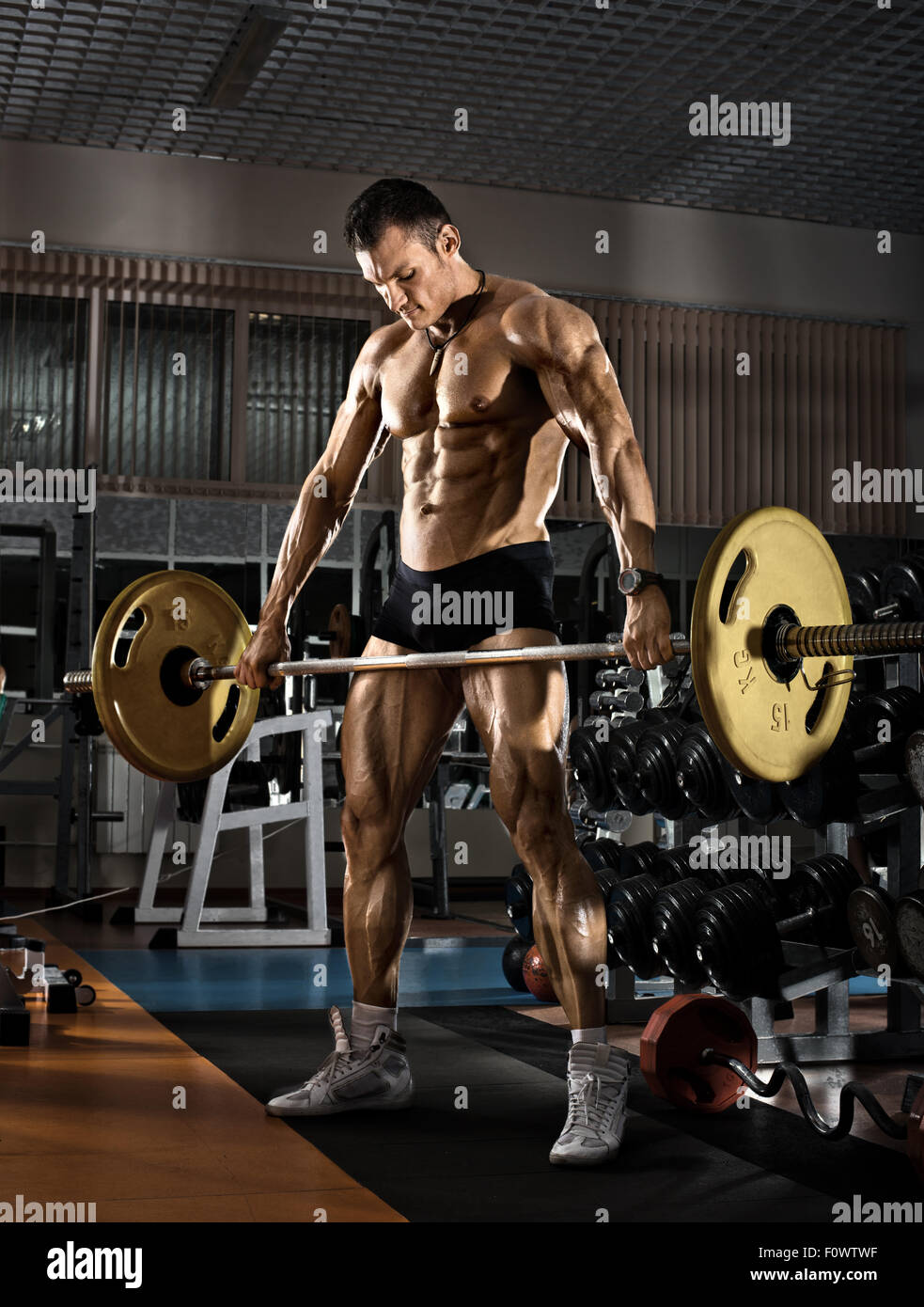 very power athletic guy bodybuilder, execute exercise with weight , in ...