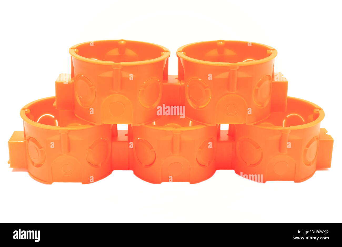 Stack of orange plastic electrical boxes on white background, junction ...