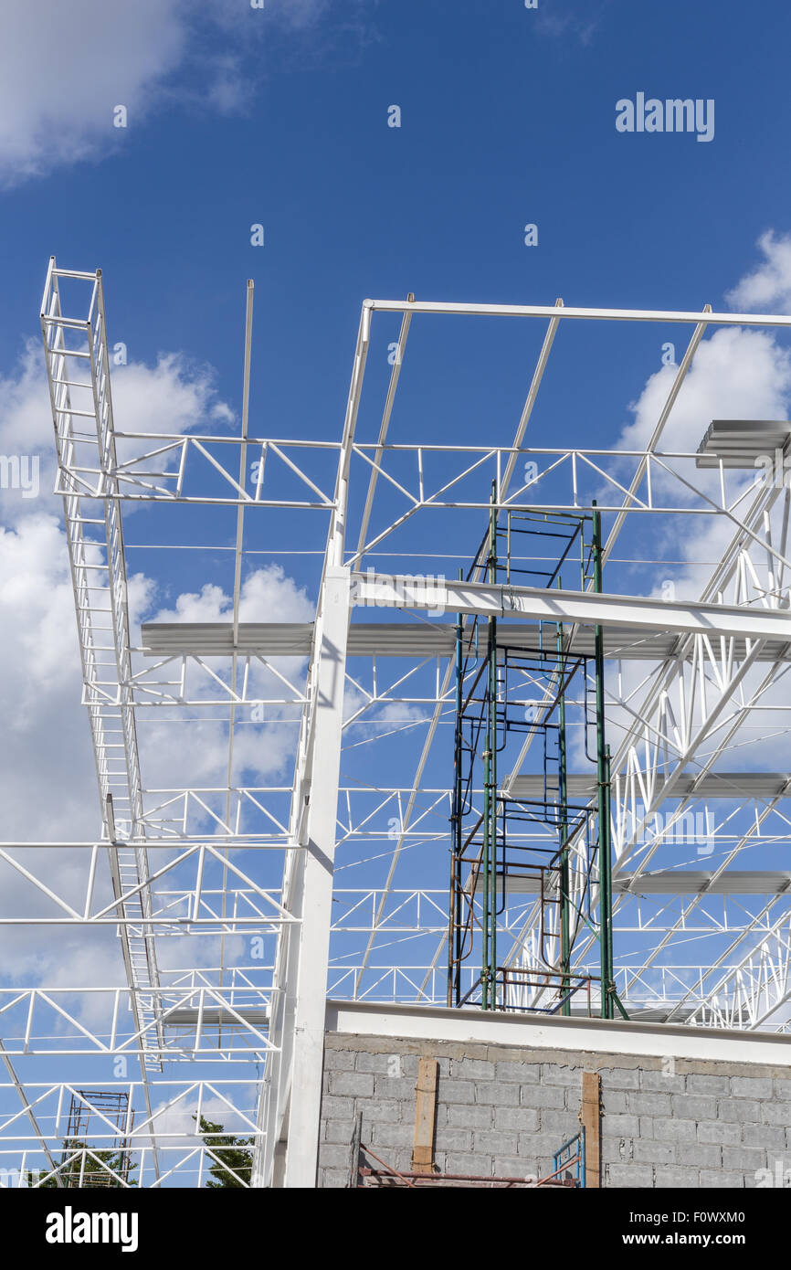 Construction of steel frame of big building with blue sky background ...