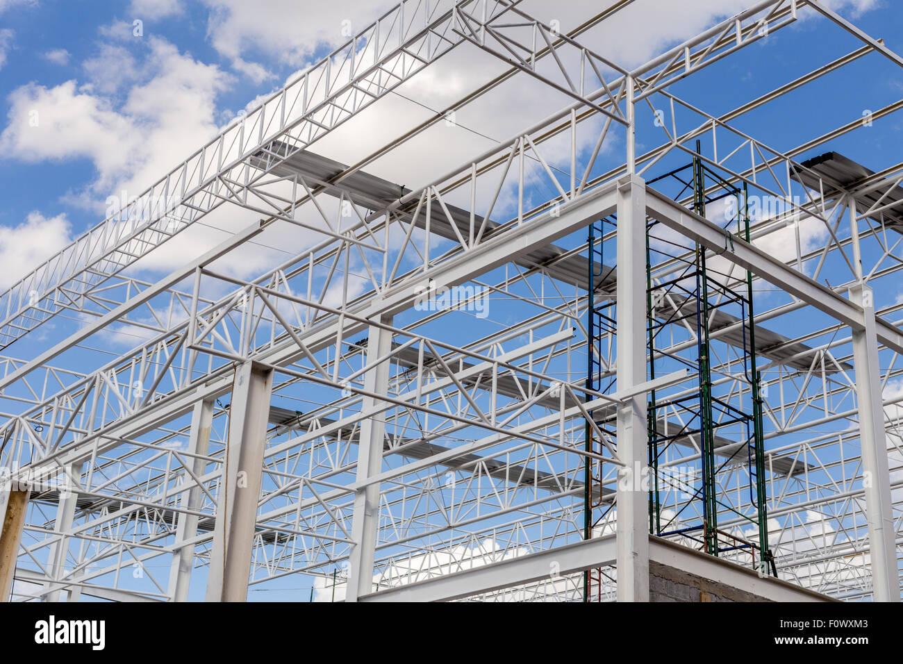 Construction of steel frame of big building with blue sky background ...