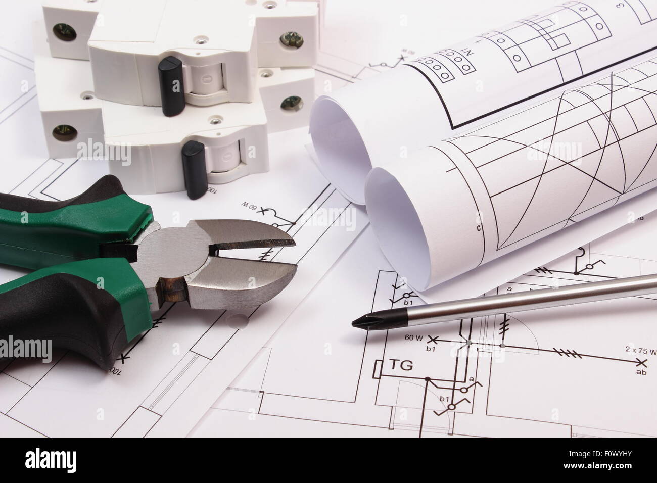 Metal pliers, screwdriver, electric fuse and rolls of diagrams on ...