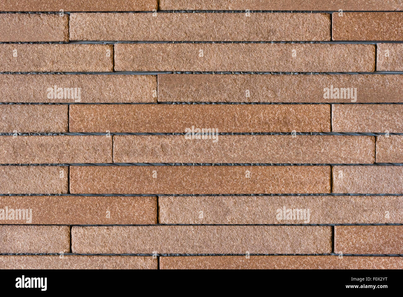 An interior wall of a house covered with long and thin brown bricks ...