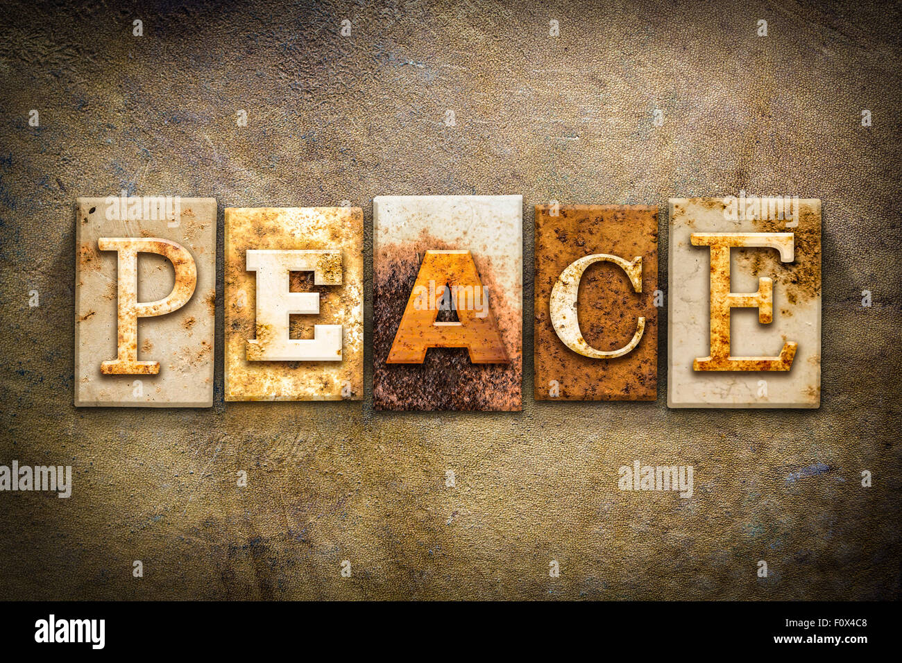 The word "PEACE" written in rusty metal letterpress type on an old aged ...